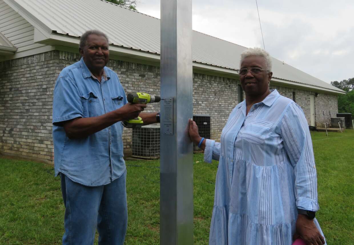 Pastor Harry and Aggie Attaching Plaque | Christian Cross Ministries