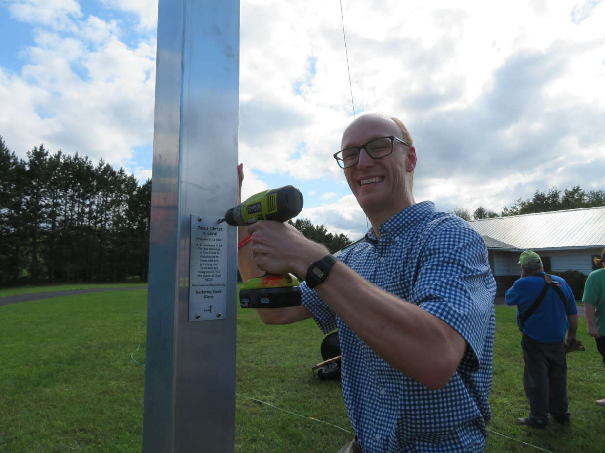 Pastor Caleb Attaching Plaque | Christian Cross Ministries